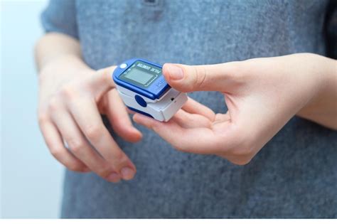 Premium Photo A Woman Checks Her Oxygen Level Using An Oximeter