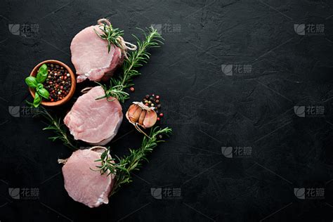 生肉迷迭香和香料在黑色的石头背景上前视图免费空间
