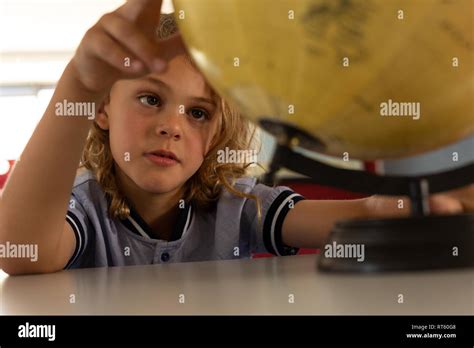 Babegirl Studying Globe At Desk In A Classroom Stock Photo Alamy