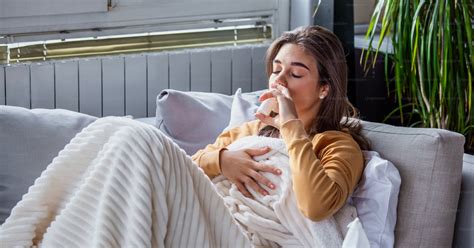 여자는 독감에 걸렸고 그녀는 자신을 돕기 위해 비강 스프레이를 사용하고 있습니다 비강 스프레이를 사용하는 여성 감기에 도움이