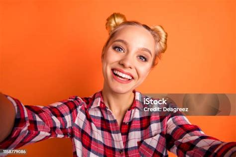 닫기 사진 좋은 그녀 그녀의 좋은 여자 이빨 빔 미소 확인 셀카 사랑스러운 십대 헤어 스타일 말 스카이프 친구 부모 캐주얼 체크 무늬 핑크 셔츠 고립 오렌지 배경을 착용