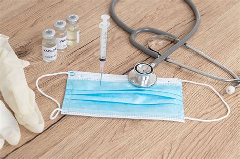 코로나바이러스 코비드19 백신 바이알과 얼굴 마스크는 의사의 책상에 넣어 0명에 대한 스톡 사진 및 기타 이미지 0명