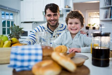 Pai e filho tomando café na cozinha Foto Premium
