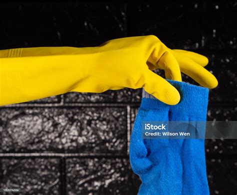 파란색 양말과 질감이 있는 검은 벽돌 배경을 들고 있는 장갑을 낀 손 T 셔츠에 대한 스톡 사진 및 기타 이미지 T 셔츠