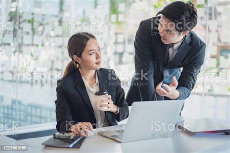 사무실에서 노트북 컴퓨터와 함께 새로운 프로젝트에 협력 하는 두 젊은 아시아 비즈니스 동료 2명에 대한 스톡 사진 및 기타