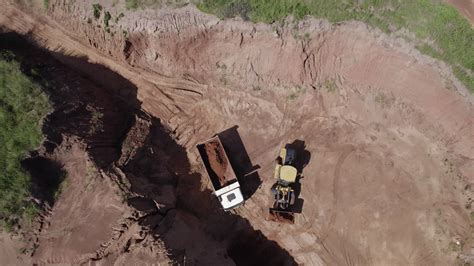 Premium Stock Video A Drone Shot Of A Digger Loading Into A Truck On