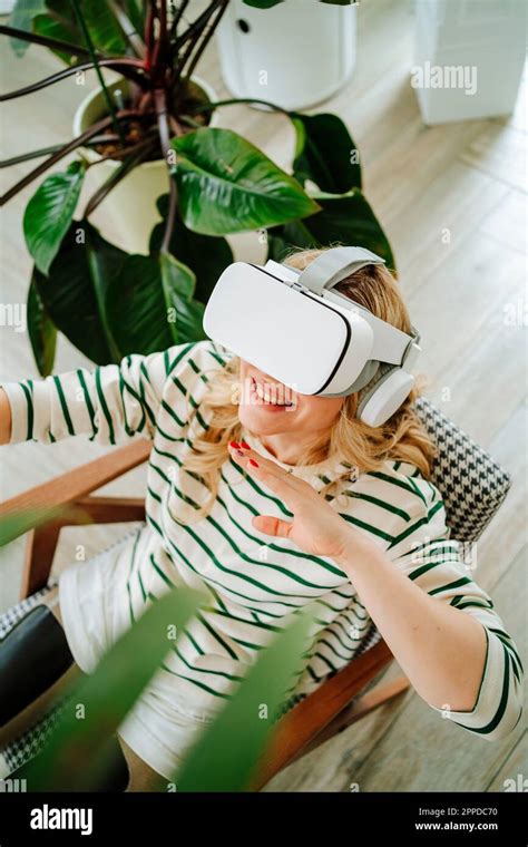 Happy Woman With Prosthetic Legs Wearing Vr Glasses Sitting At Home
