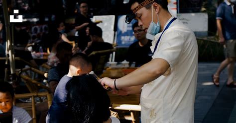 흰색 티셔츠와 검은 바지를 입은 남자가 갈색 나무 테이블 근처에 서 있다 사진 Unsplash의 무료 成都市 이미지