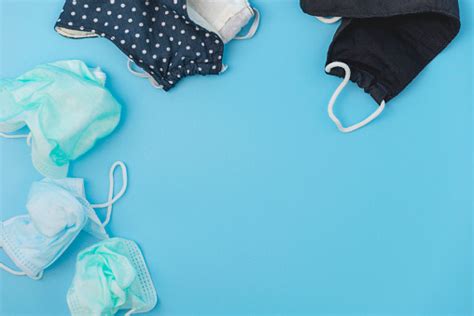 중고 의료용 얼굴 마스크와 천 마스크는 중앙 복사 공간으로 파란색 배경에 구겨졌습니다 격리 후 거부 또는 폐기 마스크의 개념 0명에 대한 스톡 사진 및 기타 이미지 Istock