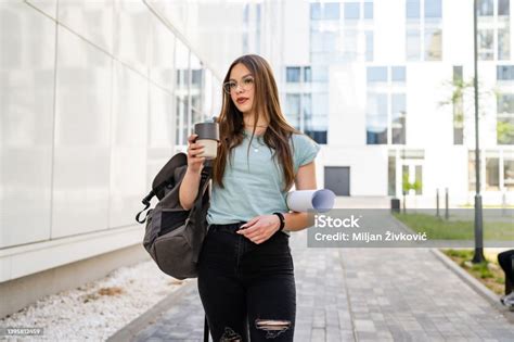 한 여성 젊은 성인 백인 여학생 밝은 날에 종이와 커피 한 잔을 들고 대학 앞에 서서 걷는 실제 사람들은 공간을 복사합니다 16 17 살에 대한 스톡 사진 및 기타 이미지