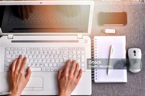 격리 된 화면이있는 흰색 노트북 키보드에 사람의 손을 입력합니다 작업 책상 테이블 개념입니다 회색 책상에 노트북 펜 및 Usb 플래시가있는 전화 및 마우스가있는 사무실