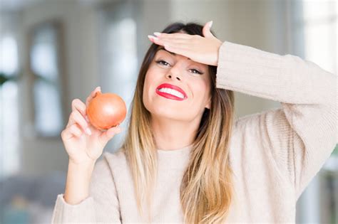 집에서 신선한 양파를 들고 젊은 아름다운 여자는 머리에 손으로 스트레스 수치와 깜짝 얼굴 분노와 좌절에 충격 실수에 대한