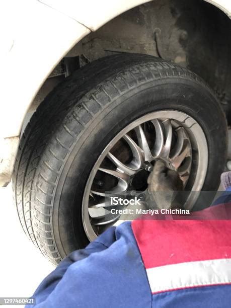 외부 타이어를 변경 전기 드라이버와 자동차 정비사 남자 자동차 서비스 타이어 설치 개념 겨울 과 여름 타이어의 교체 손은 바퀴에 타이어를 교체합니다 교통수단에 대한 스톡