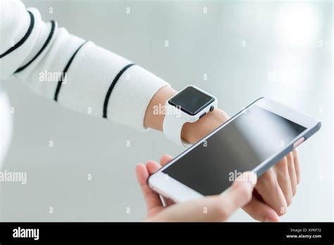 Woman Connecting Smartwatch And Mobile Phone Stock Photo Alamy