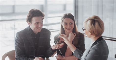 이제 그녀의 꿈이 이루어집니다 자동차 판매원은 젊은 매력적인 소유자에게 새 차의 열쇠를줍니다 사진 Unsplash의 양복 이미지