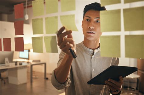 아시아 사업가 태블릿 및 야간 사무실 디지털 마케팅 일정 전략 계획 또는 브랜드 목표에 대한 스티커 메모 비전 목표를 위한