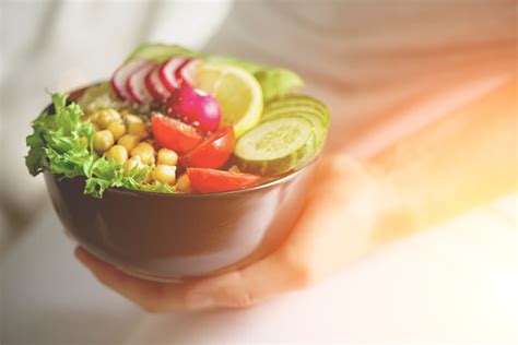 백인 청바지 여자 손에 포크 아보카도 노아 오이 무 샐러드 레몬 체리 토마토 Chickpea Chia의 종자와 그릇에 채식 아침 식사에에서 보유 하고있다 보기 상위 공간을