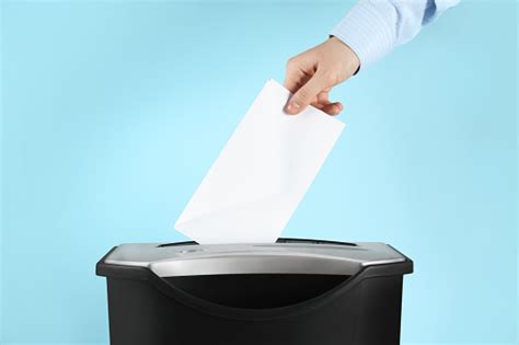 하늘색 배경에 분쇄기로 봉투를 파괴하는 여자 근접 촬영 갈기갈기 찢어진에 대한 스톡 사진 및 기타 이미지 갈기갈기 찢어진