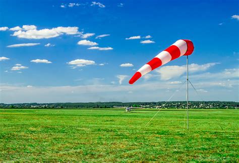 푸른 하늘 녹색 필드와 비행장 또는 비행장에 구름 배경에 빨간색과 흰색 Windsock 바람 양말 풍속 및 방향을 표시합니다 바람자루에 대한 스톡 사진 및 기타 이미지