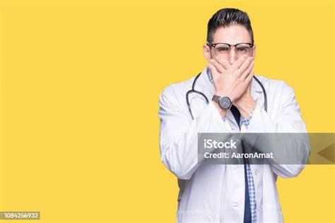 입 실수에 대 한 손으로 다루는 충격된 절연된 배경 위에 잘생긴 젊은 의사 남자 비밀 개념입니다 가리기에 대한 스톡 사진 및 기타 이미지 Istock