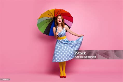 긍정적 인 쾌활한 아가씨의 전신 사진 은 비가 날 예보 날씨 웃음 터치 폴카 도트 스커트 착용 노란색 팬티 스타킹 빨간 신발 분홍색 색상 배경 위에 고립 노랑에 대한 스톡