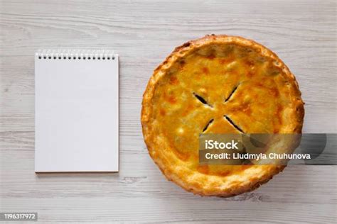 집에서 구운 캐나다 투르티에르 고기 파이 흰색 나무 배경에 빈 메모장 상단 보기 평면 누워 오버 헤드 위에서 공간을 복사합니다