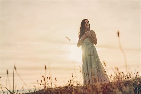 여자 석양 햇빛에서 백라이트에 모래 언덕에 서 서 들고 있는 야생화 꽃 식물에 대한 스톡 사진 및 기타 이미지 꽃 식물 드레스 천상의 Istock