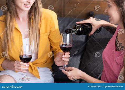 Partial View Of Two Lesbians Holding Wine Glasses And Pouring Wine