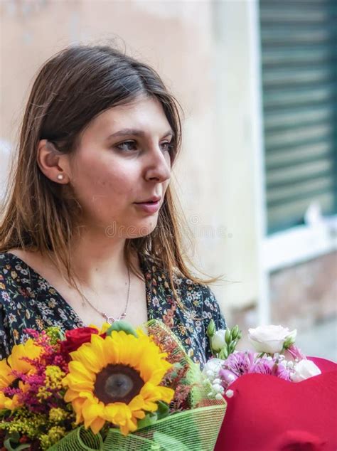 Jovencita Sin Maquillaje Sonriendo Con Ramos De Flores En La Mano Con