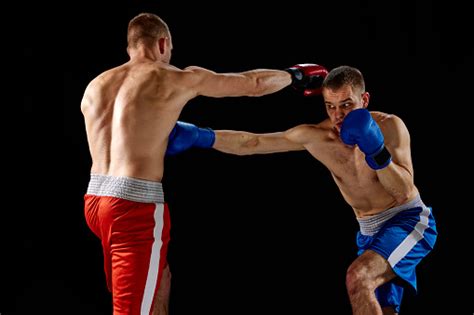 파란색과 빨간색 스포츠 유니폼을 입은 남성 프로 복서들은 어두운 배경에 고립된 펀치를 연습합니다 스포츠 경쟁 훈련 에너지의 개념 20 24세에 대한 스톡 사진 및 기타
