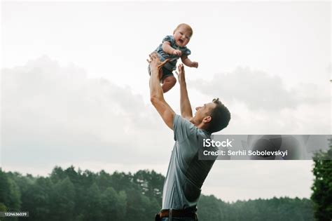아버지는 자연에서 아기를 던져 소녀는 하늘에 날아 함께 아이와 함께 초상화 아빠 아빠 야외에서 어린 딸 아기 소녀와 젊은 아버지는 공원에서 산책 가족 휴가 2명에 대한 스톡