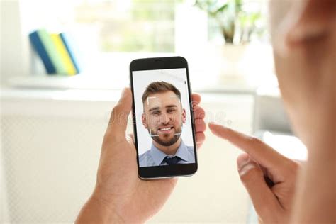 Man Using Smartphone With Facial Recognition System Indoors Biometric Verification Stock Image