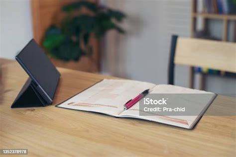 플래너는 캘린더 책에서 회의 의제를 작성하고 집에서 온라인으로 작업합니다 주최자가 사무실 책상에서 시간표 일일 약속 및 관리 작업을 계획할 수 있는 일기 및 태블릿 플래너