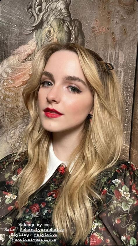 A Woman With Long Blonde Hair And Red Lipstick Is Posing For A Photo In