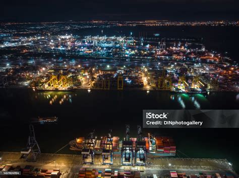 조감도 국제 선적 항구 선적 및 크레인으로 컨테이너를 선적 및 하역하여 운송 선박 및 트레일러에 선적 및 수입 수출을 위해 고객과 소비자에게 제품을 배포하는 조명 도시 배경