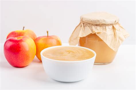흰 그릇에 담긴 신선한 수제 사과소스와 흰 테이블에 과일 퓌레를 곁들인 항아리 적절한 영양과 건강한 식습관의 개념 유기농 및 채식 식품 이유식 텍스트 공간 복사 애플 소스에