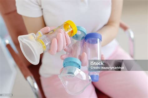 분홍색 수술 장갑을 낀 의사가 천식 흡입기 에어로졸 스페이서를 손에 들고 있습니다 흡입 챔버 실리콘 마스크 어린이 치료 호흡기 감염 개념에 대한 스톡 사진 및 기타 이미지