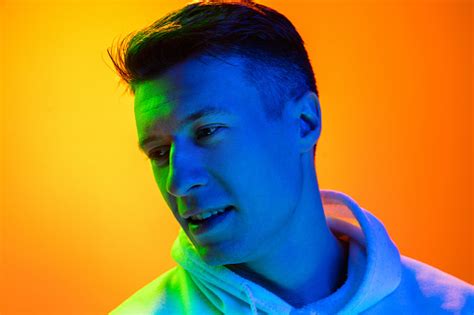 여러 가지 빛네온 빛에 노란색 스튜디오 배경에 고립 된 백인 아름다운 남자의 초상화 사람들에 대한 스톡 사진 및 기타 이미지 사람들 네온 조명 장비 Istock