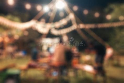 Blurred Scene Of Group Of Friends With Bbq Picnic Party And Illuminated