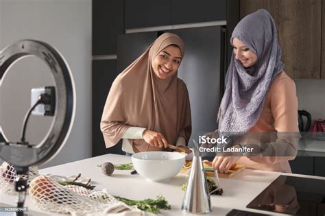 부엌에서 샐러드를 준비하는 방법을 설명하는 두 명의 무슬림 음식 Vloggers 요리하기 음식 준비에 대한 스톡 사진 및 기타 이미지 요리하기 음식 준비 브이로깅