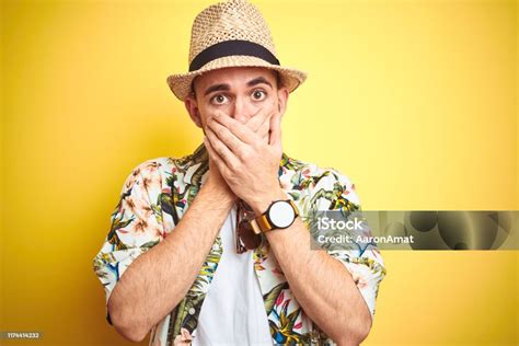 하와이 꽃 셔츠와 여름 모자를 입고 휴가에 젊은 남자는 실수로 손으로 입을 덮고 충격을 노란색 배경에 비밀 개념입니다 남자에 대한 스톡 사진 및 기타 이미지 Istock