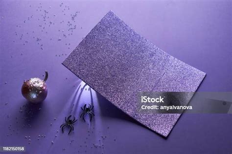 빛나는 종이 카드 아래 긴 그림자를 따라 기어 다니는 거미와 두 개의 빛나는 호박 화가 금속 색상과 창조적 인 보라색 할로윈 모형 복사 공간 0명에 대한 스톡 사진 및 기타