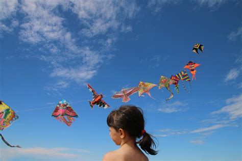Premium Photo Low Angle View Of Girl By Kites Flying In Sky