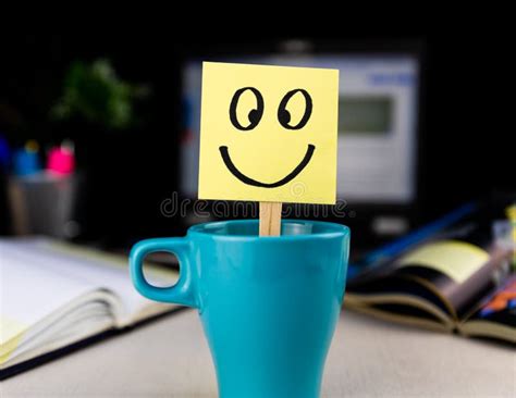 Smiling Face Drawn On Sticky Note Inside A Cup Of Coffee At The Office