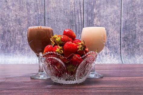 잘 익은 붉은 딸기와 칵테일 두 잔을 곁들인 크리스탈 꽃병이 나무 테이블 위에 서 있습니다 0명에 대한 스톡 사진 및 기타 이미지 Istock