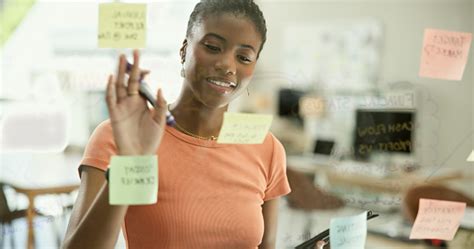 여성 사무실에서 브레인스토밍 사고 및 프로젝트 관리를 위한 태블릿이 있는 스티커 메모 또는 유리 보드 젊은이 벽에 스크럼을 짜고