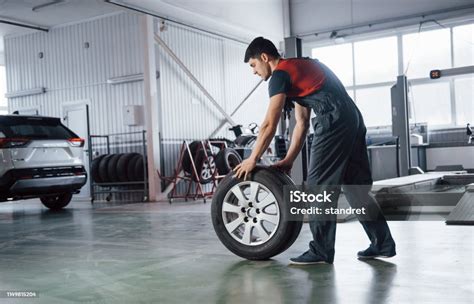 자동차로가는 길에 수리 차고에 타이어를 들고 정비사 겨울 및 여름 타이어 교체 검은색에 대한 스톡 사진 및 기타 이미지 검은색 교통수단 굴리기 Istock