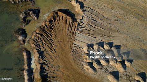 노천 모래 광산의 아리알 전망 프론트 로더는 더미에서 모래를 적재합니다 채석장에서 일하는 무거운 광산 기계 많은 바퀴 트랙과 사막 모래 언덕이나 가슴과 같은 모래 더미 건조