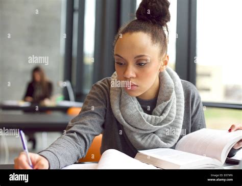 Close Up Image Of A Young Female Student Doing Assignments In Library