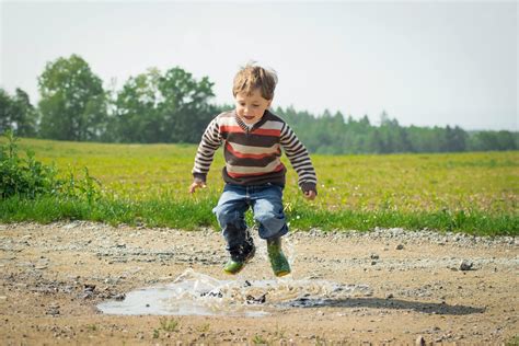 Niño Saltando Cerca De La Hierba Durante El Día · Fotos De Stock Gratuitas
